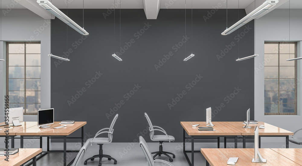 Side view of a modern office with a grey wall. Rows of tables, equipped ...