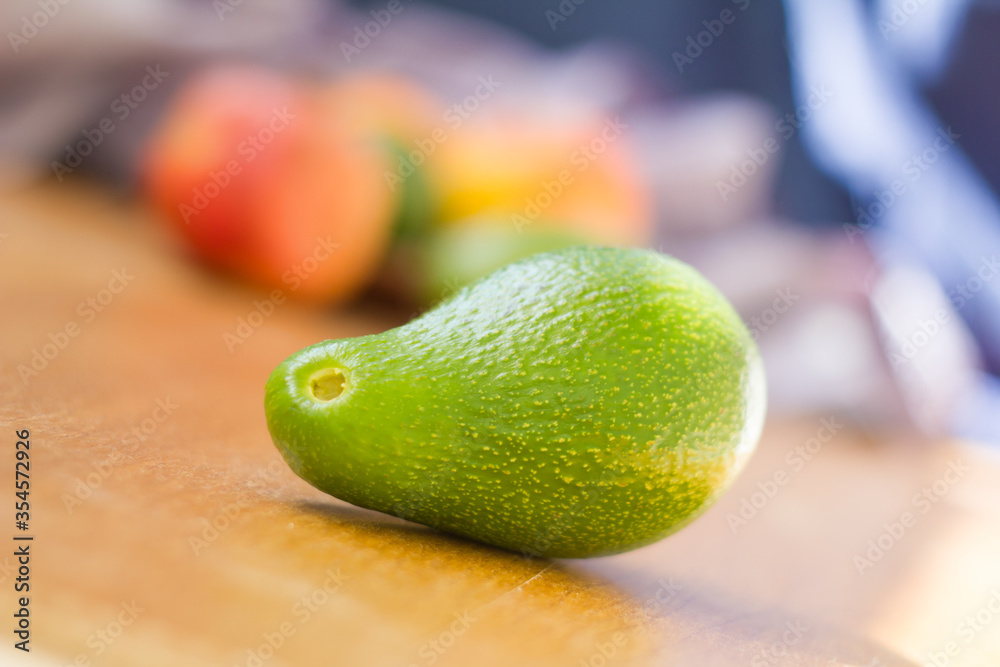 Avocado fuerte with fruits on the background, avocado in front of ...