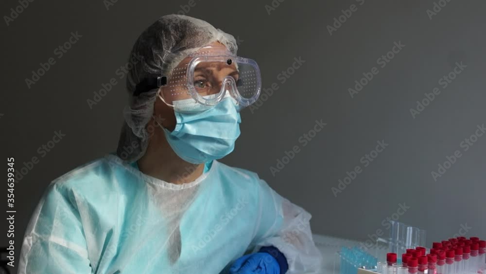 Close up portrait of a tired lab technician with sad eyes at the desk ...