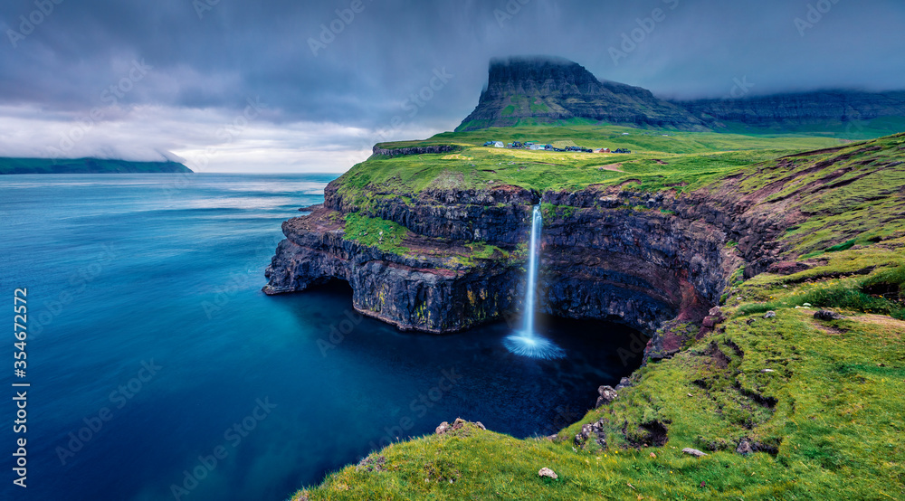 Dramatic evening view of Mulafossur Waterfall. Dark cloud on Vagar ...