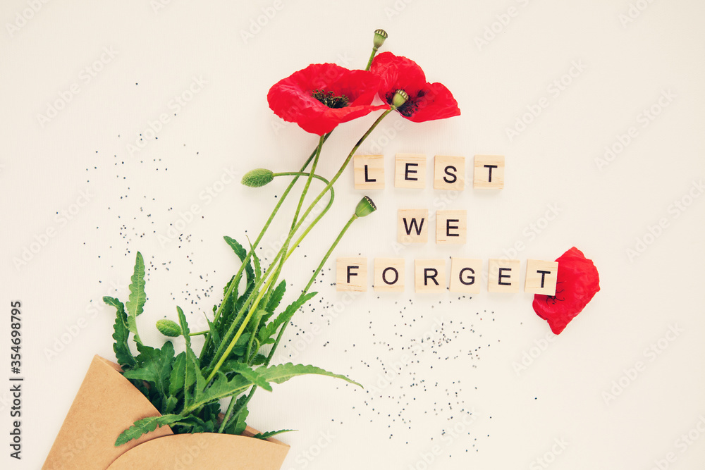 Red poppy flowers in envelope on white background. Wooden alphabet text ...
