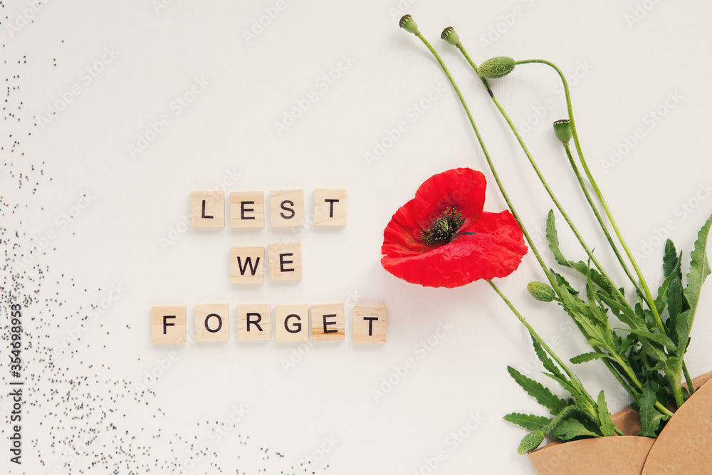 Red poppy flowers in envelope on white background. Wooden alphabet text ...