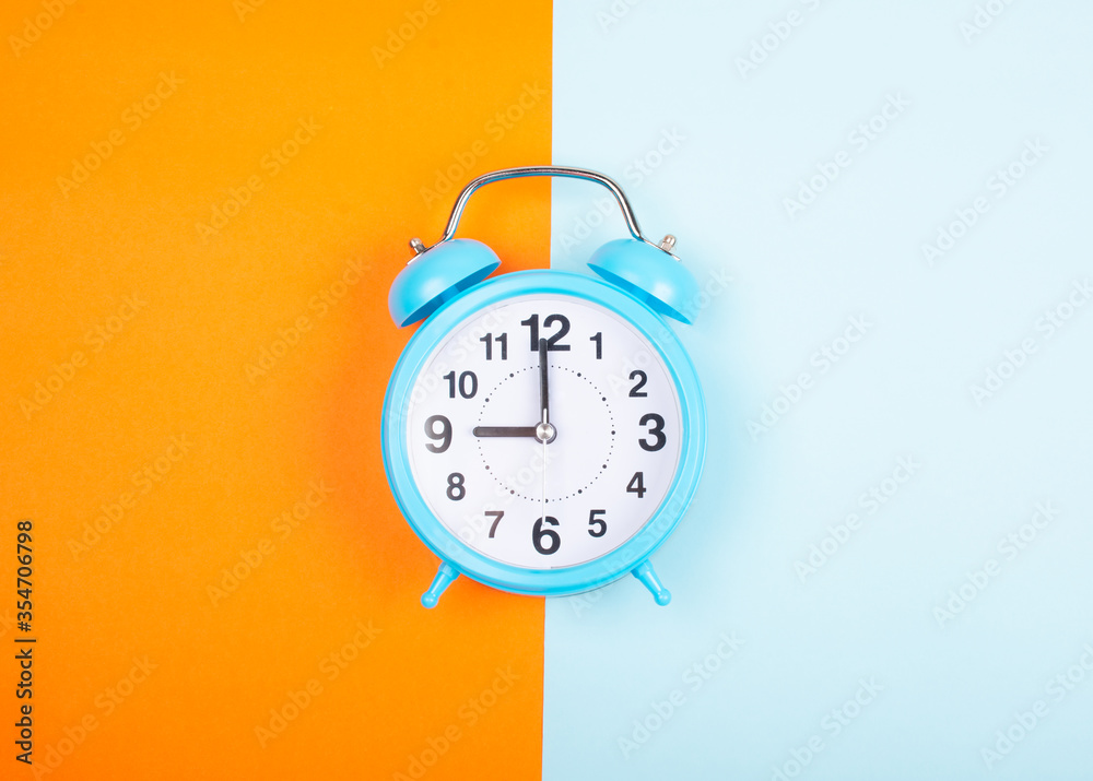 Blue alarm clock on a split orange and light blue background Stock ...