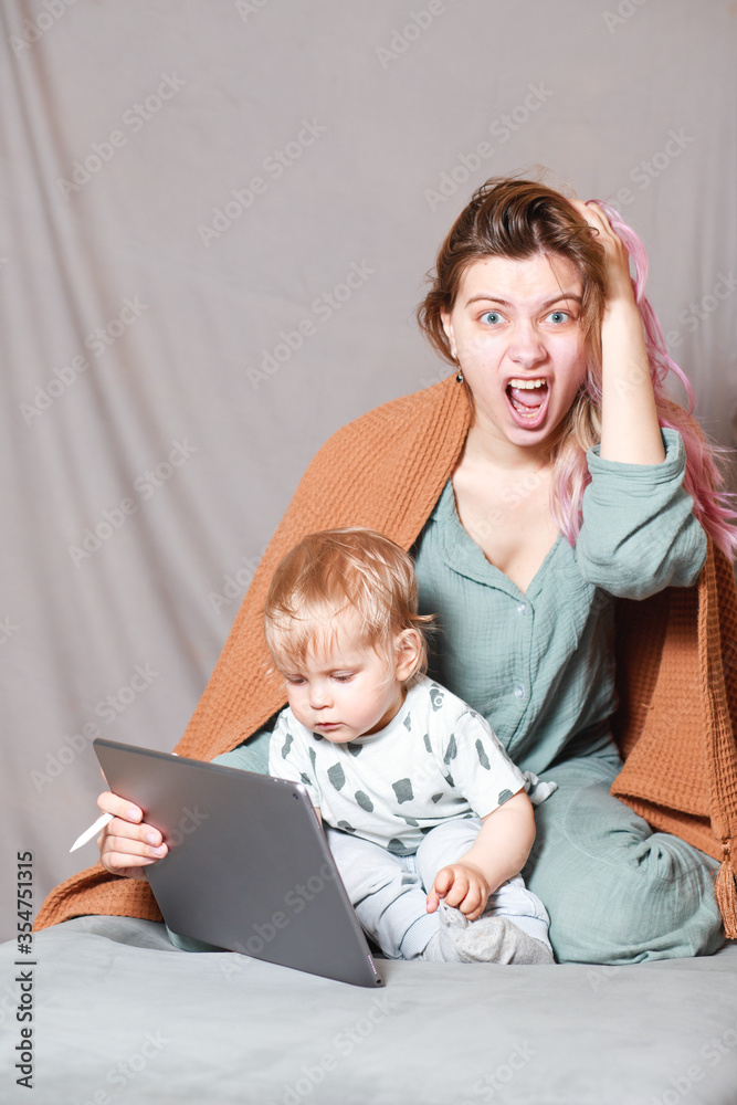 Stay at home, mom works remotely on a laptop computer, taking care of ...