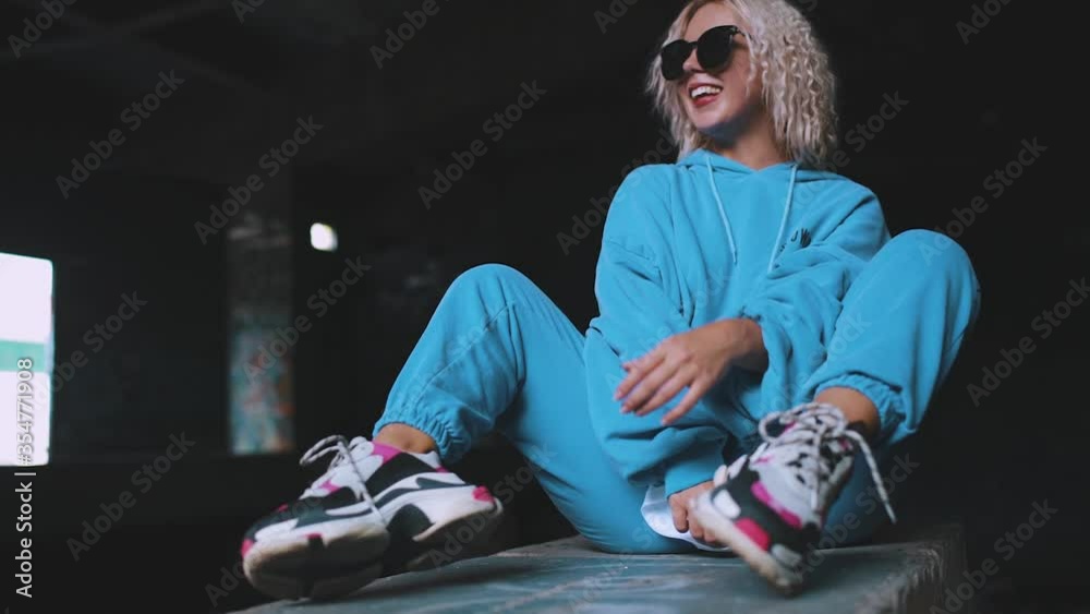 Pretty female model sitting on the floor and clapping with her hands ...