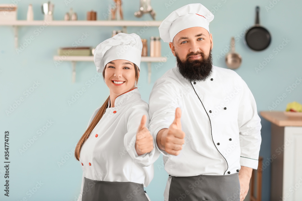 Male and female chefs showing thumb-up in kitchen Stock Photo | Adobe Stock