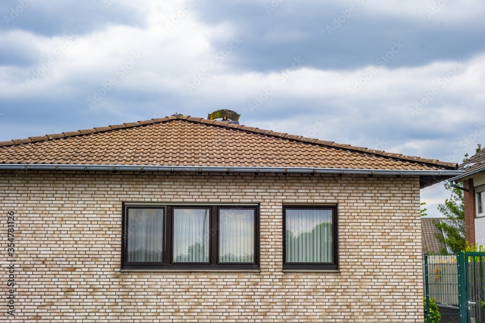 Beautiful brick building with three windows captured under the cloudy ...