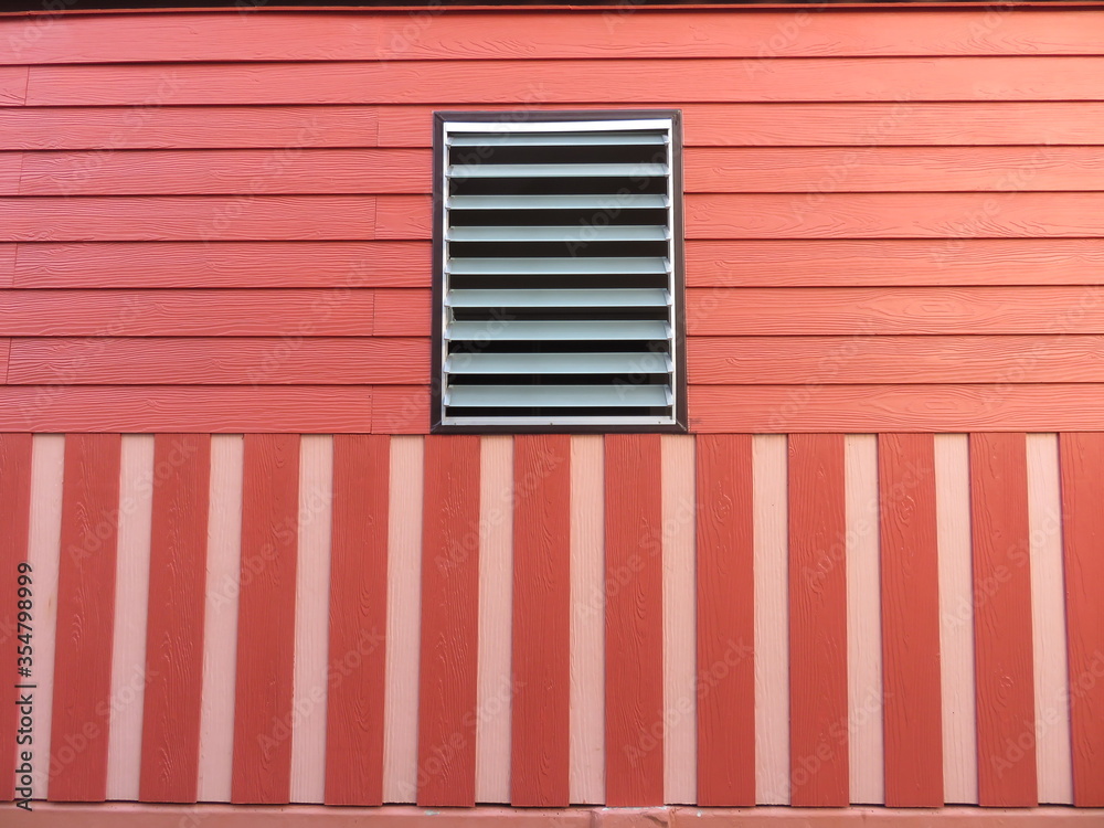 Slat window on the red wall which made from the artificial wooden ...