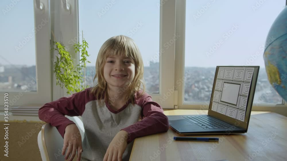 Child studing online by conference call using laptop. Boy smiling ...