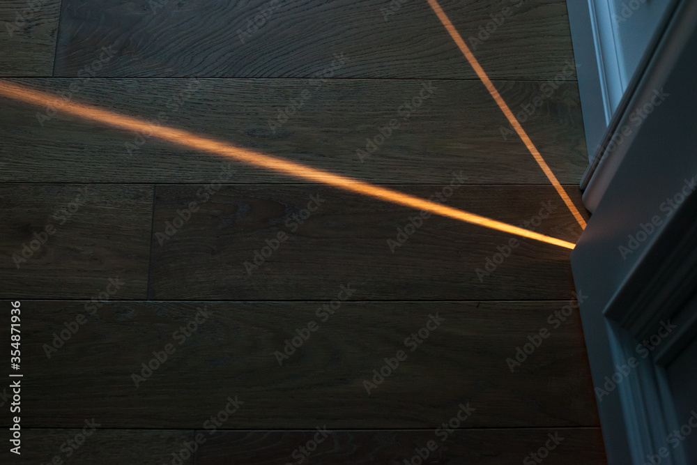 Warm ray of lights shining in the floor of dark room through the ...