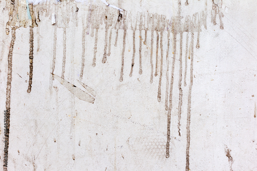 Dirty beige concrete wall with streaks of water, cracks and scratches ...