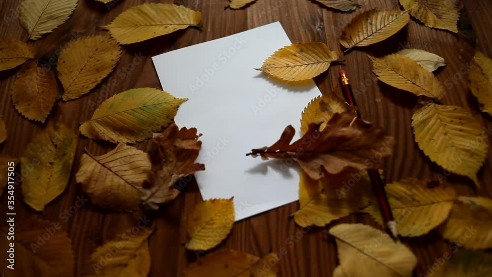 Blank paper, autumn leaves and pencil on the table. Autumn leaves fall ...