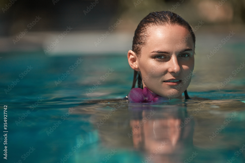 Stunning young girl with dark wet hair standing half water of swimming ...