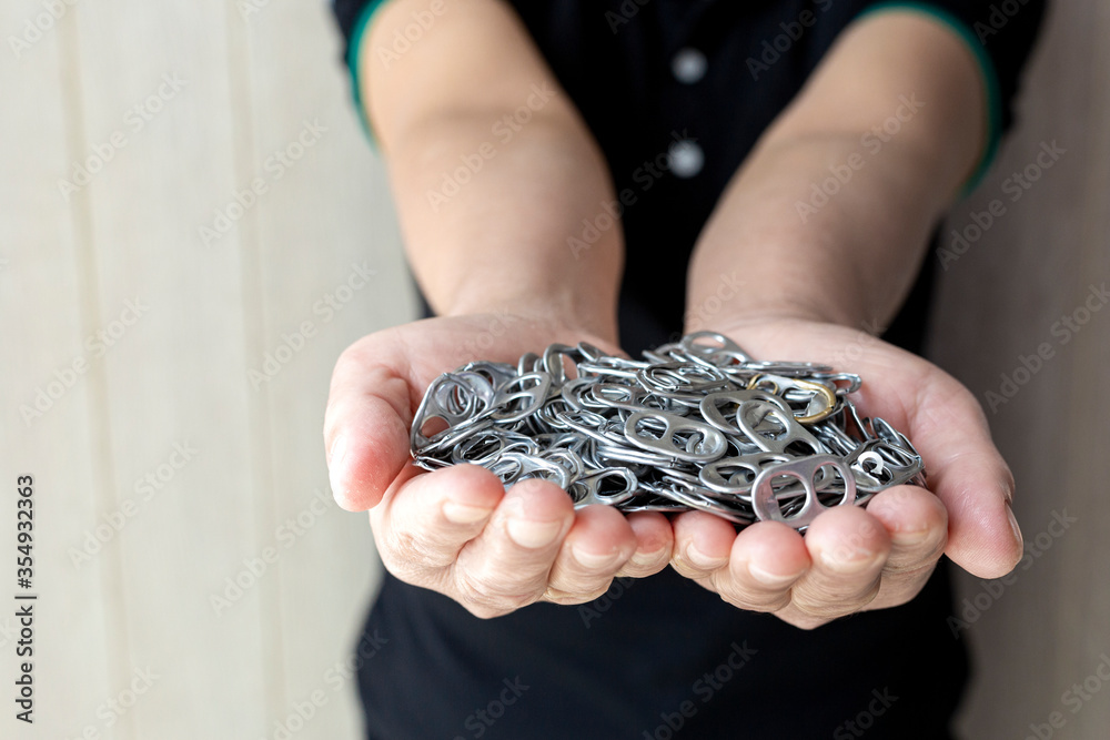 Hand holding stack of ring pull aluminum of cap cans.Raw materials for ...