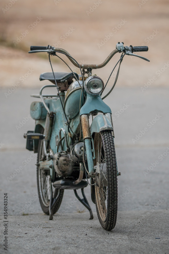 Frontal view of an old blue moped or scooter from the 1950 or fifties ...