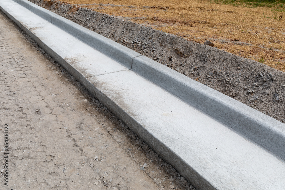 Road construction details, extruded concrete curb beside freshly ...