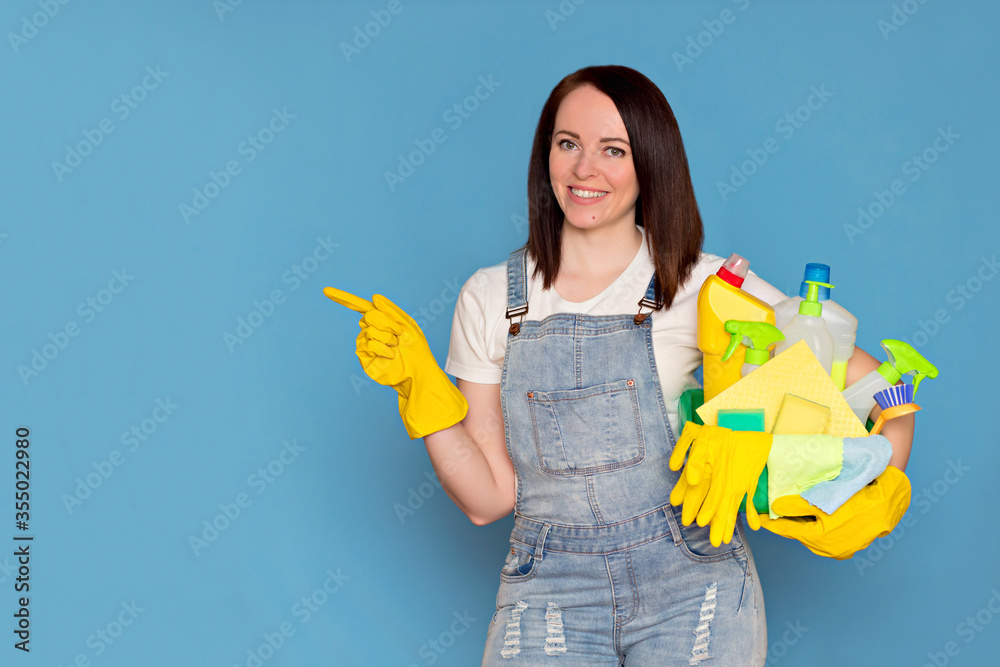 Beautiful woman cleaning lady with a bucket full of colorful detergent ...