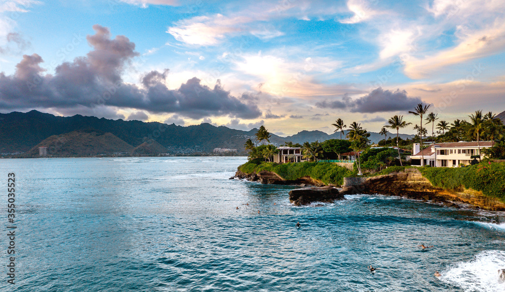 Aerial view of sunny village in Hawaii with houses on the cliffs by the ...