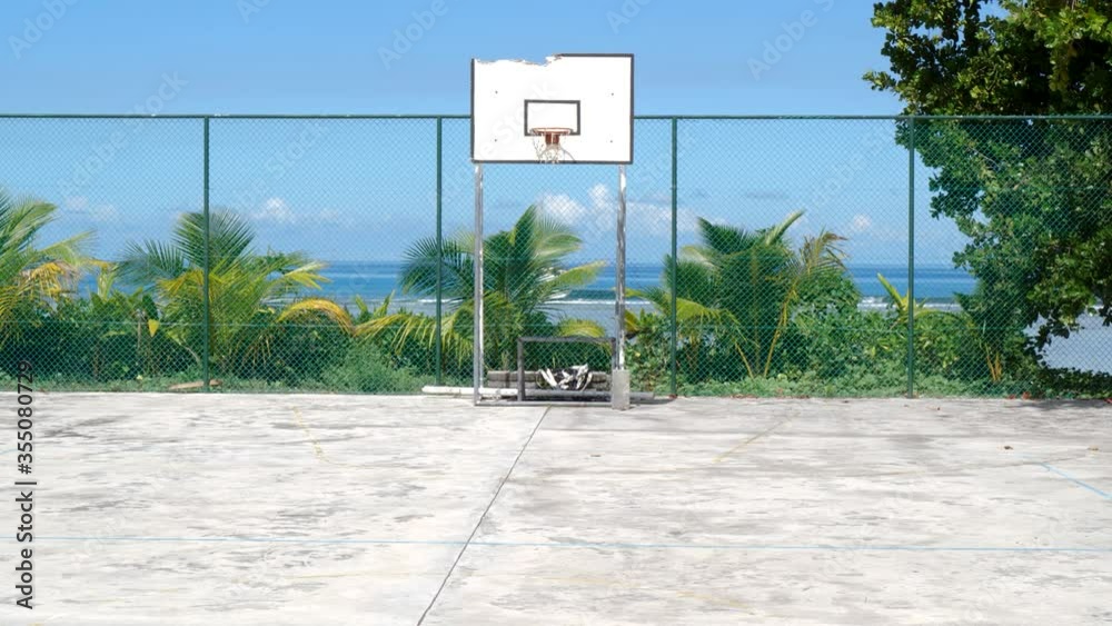 Derelict basketball court on a tropical island, waves and beautiful ...