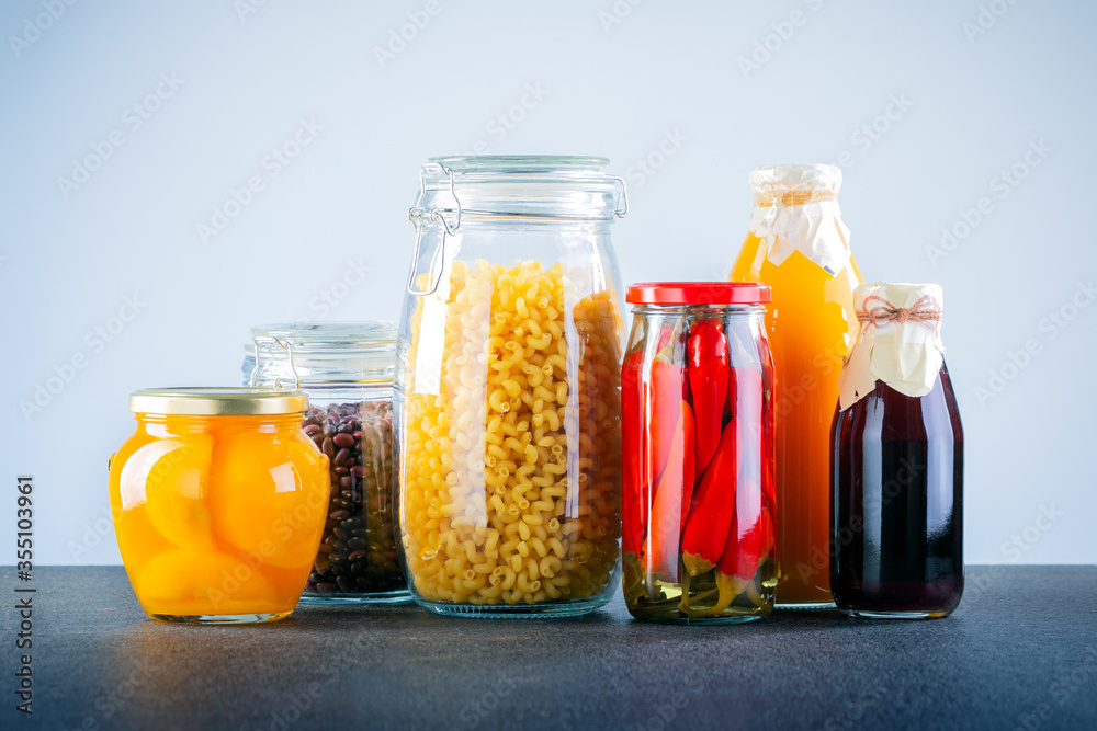 Glass jars with different types of groat, pasta, vegetable and juice ...