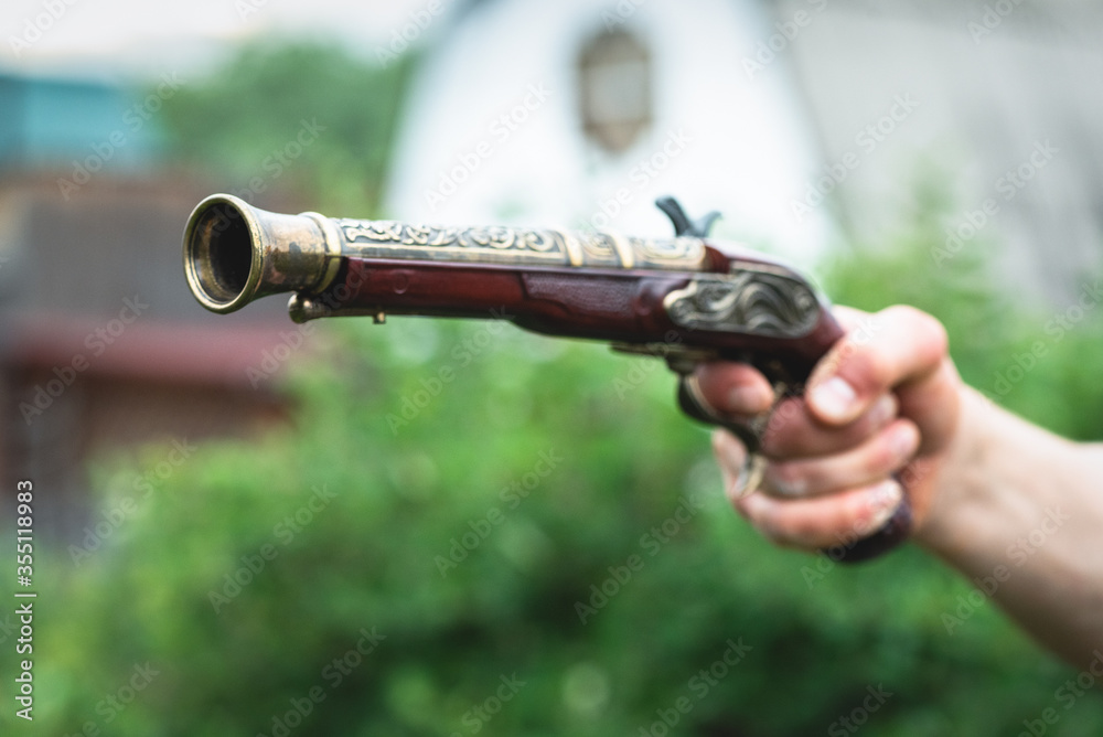 Old musket gun in a pirate hand close up. Duel. Stock Photo | Adobe Stock