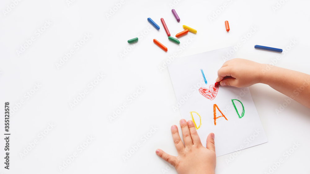 Toddler draws greeting card for Father's day. Kid uses wax crayons to ...