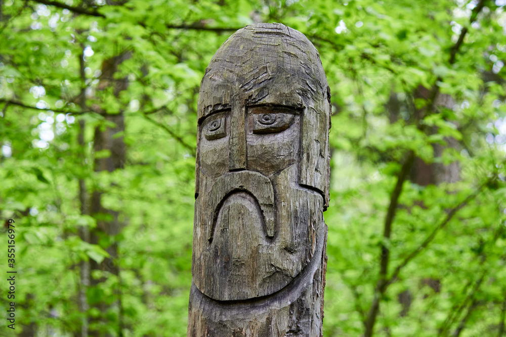 The image of the Slavic deity Veles carved from a tree trunk on a neo ...