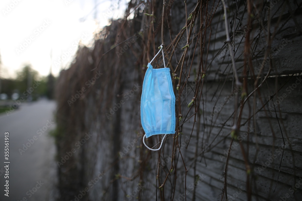 Disposable face mask. Surgical masks are used carelessly scattered on ...