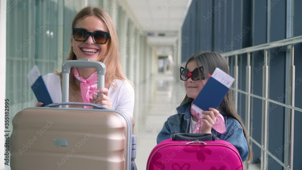 Female and little girl holding passports and airline boarding pass ...
