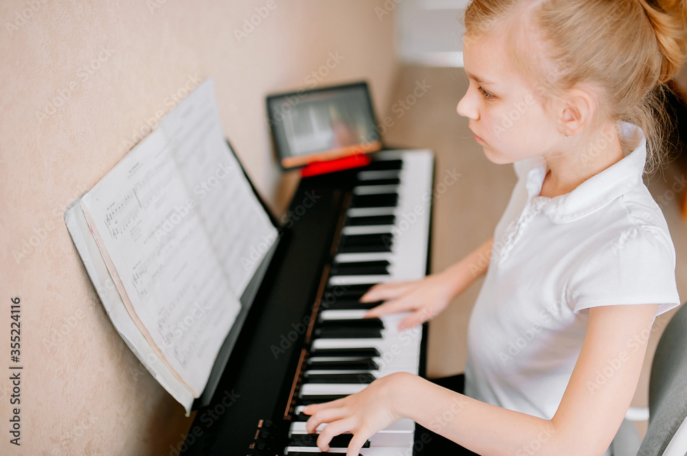 Pretty young musician playing classic digital piano at home during ...
