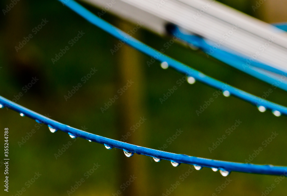 Blue clothing lines of a clothes spin with many raindrops at the string ...