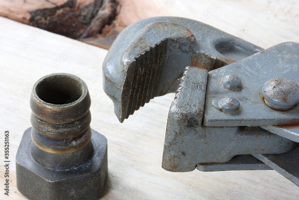 Flexible hose adapter and gray pipe wrench Stock Photo | Adobe Stock