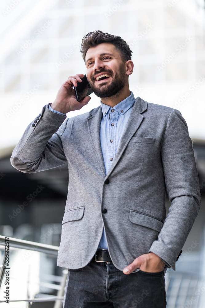 Portrait of a businessman having mobile phone conversation while ...
