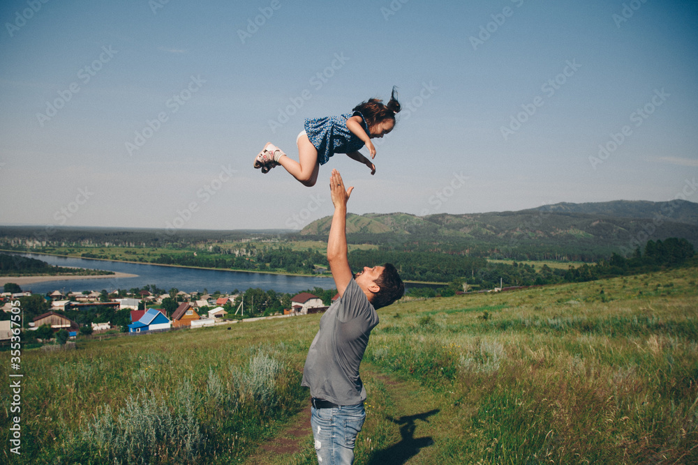 father walks with his daughter in meadow. man throws child. Baby in ...