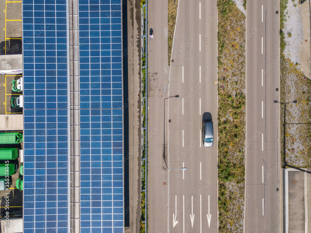 Aerial view of rooftop solar panel on building and road. Urban traffic ...