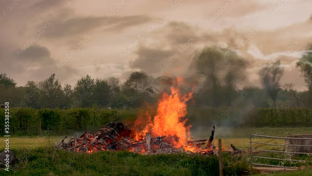 Garbage wood burning in an open field, big fire in slow motion Stock ...