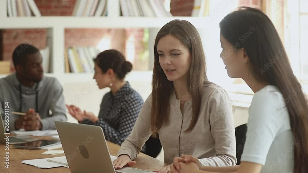 Young caucasian female teacher mentor teaching asian student intern ...