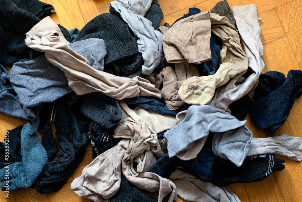 Messy pile of old worn out textile socks in a clutter. Concept of ...