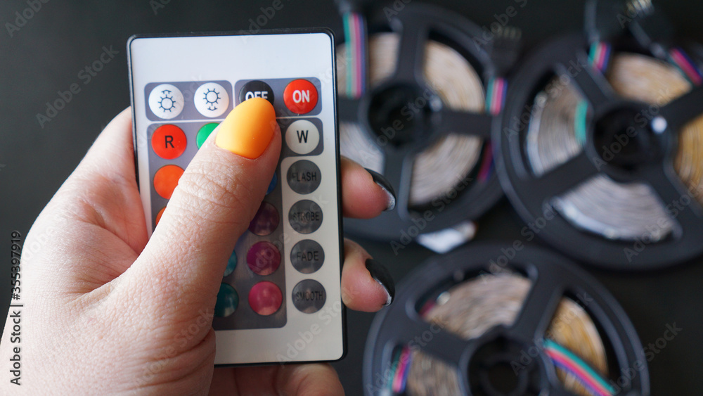 Remote control for change colors in hand on blurred background with led ...