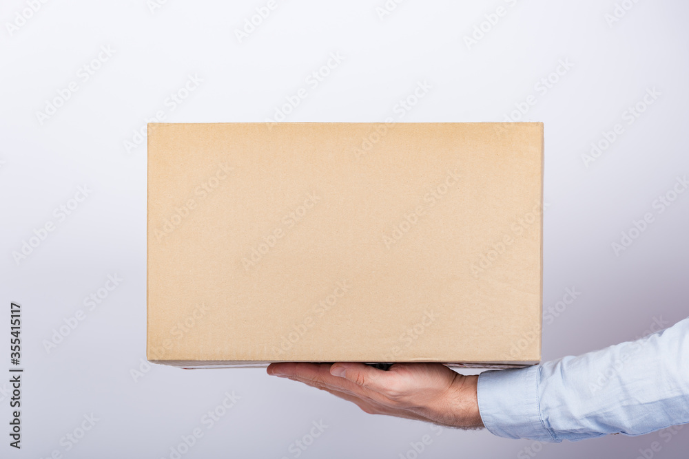 Cardboard box in male hands. Parcel delivery home. Side view Stock ...