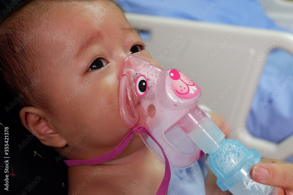 Sick boy inhalation therapy by the mask of inhaler. Boy is sick with ...