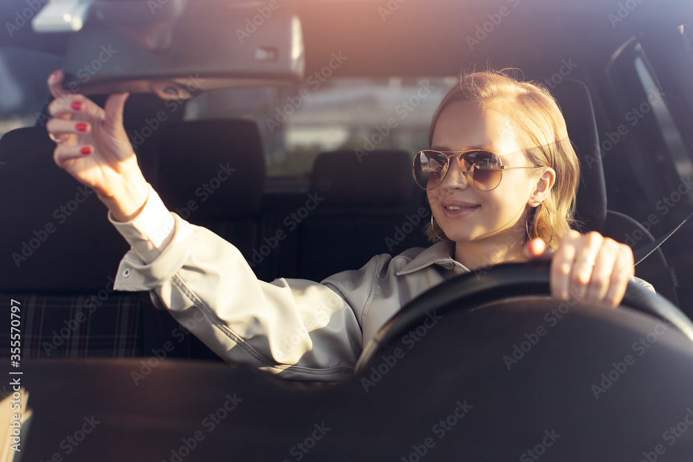 Woman in sunglasses, new driver sitting in car, riding on road ...