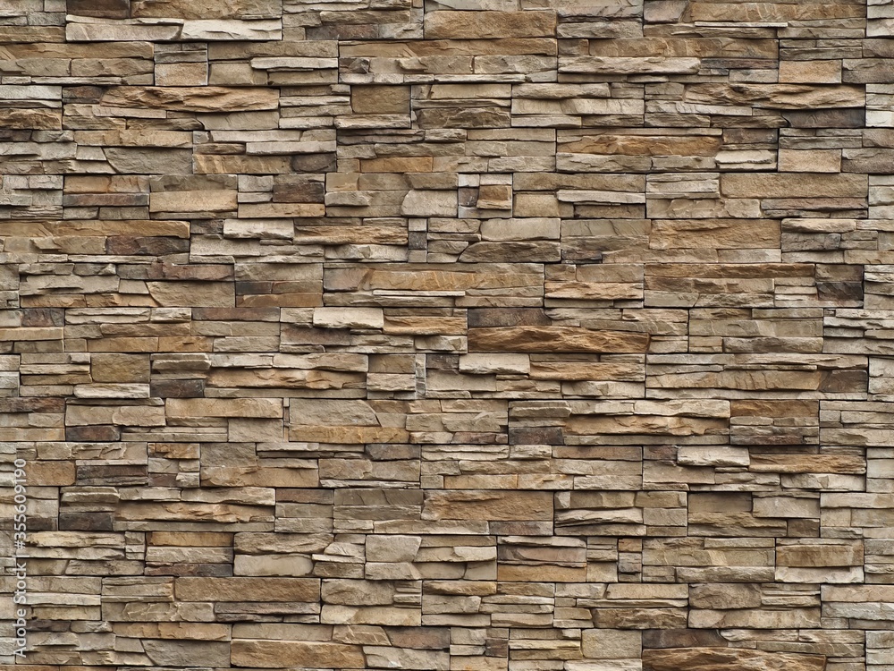 Stone cladding wall made of striped stacked slabs of natural brown ...