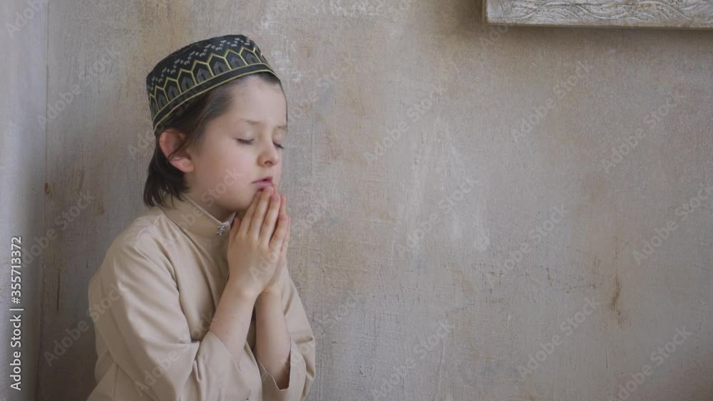 Muslim child in prayer hat and arabic clothes with rosary beads and ...