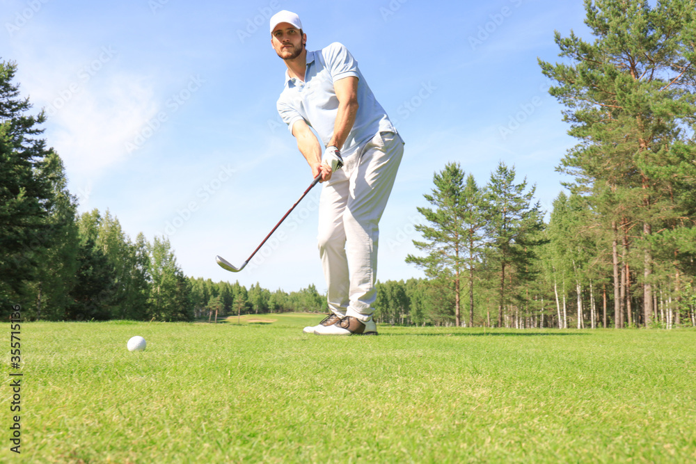 Full length of golf player playing golf on sunny day. Professional male ...