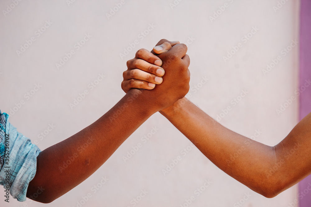 Black and white human hands in a modern handshake to show each other ...