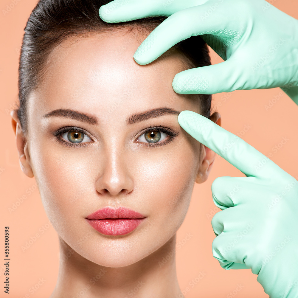Face skin check before plastic surgery. Beautician touching young woman ...