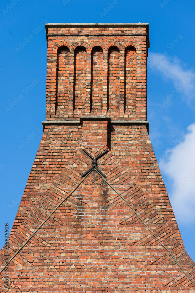 Stepped gable and tall brick chimney on the roofs of houses in Bruges ...