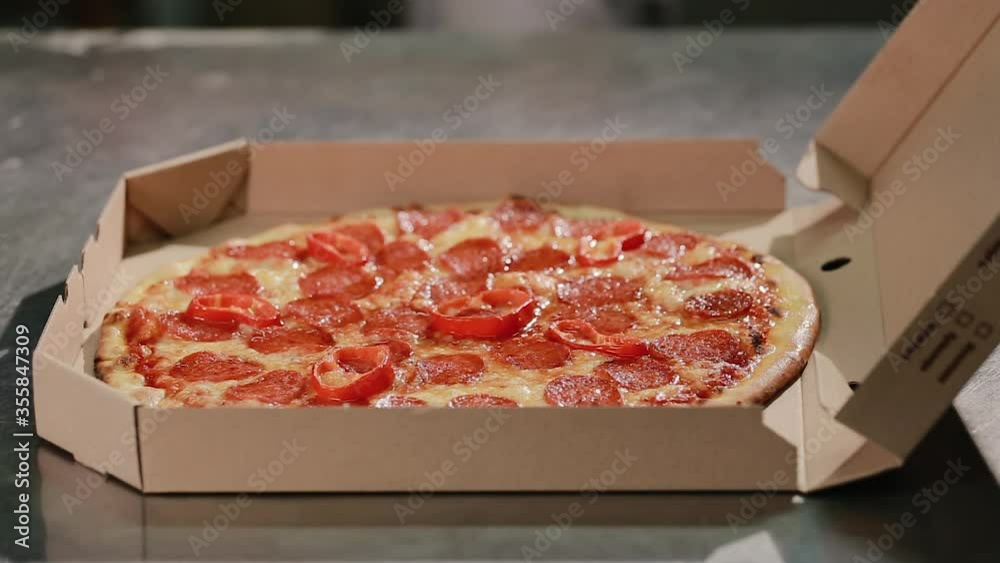 Close up hands professional chef puts just now cooked pizza from oven ...