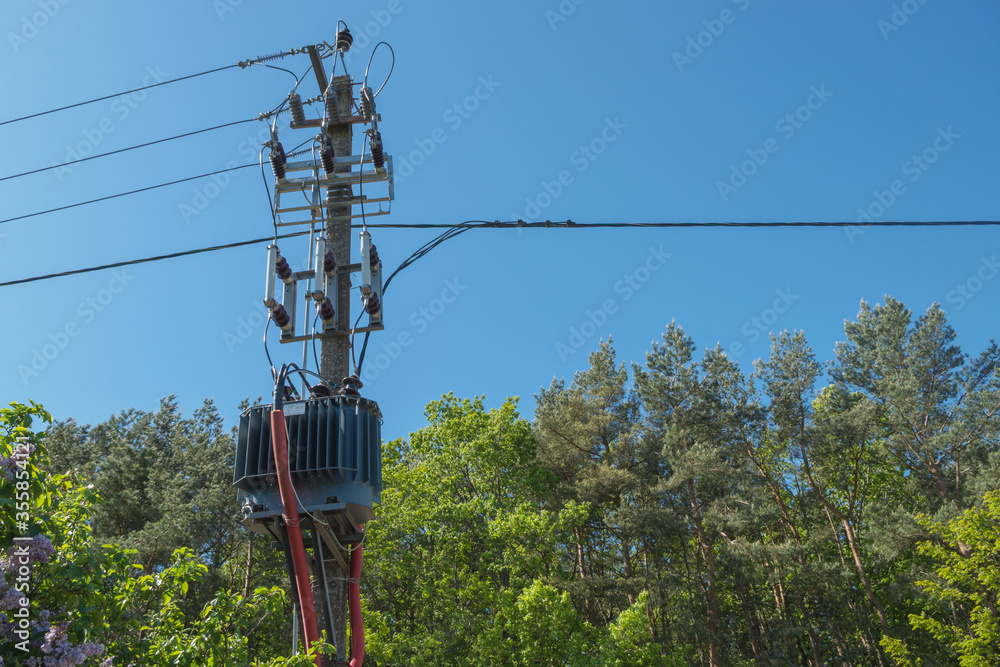 Ribbed grey distribution transformer that is connected to incoming ...